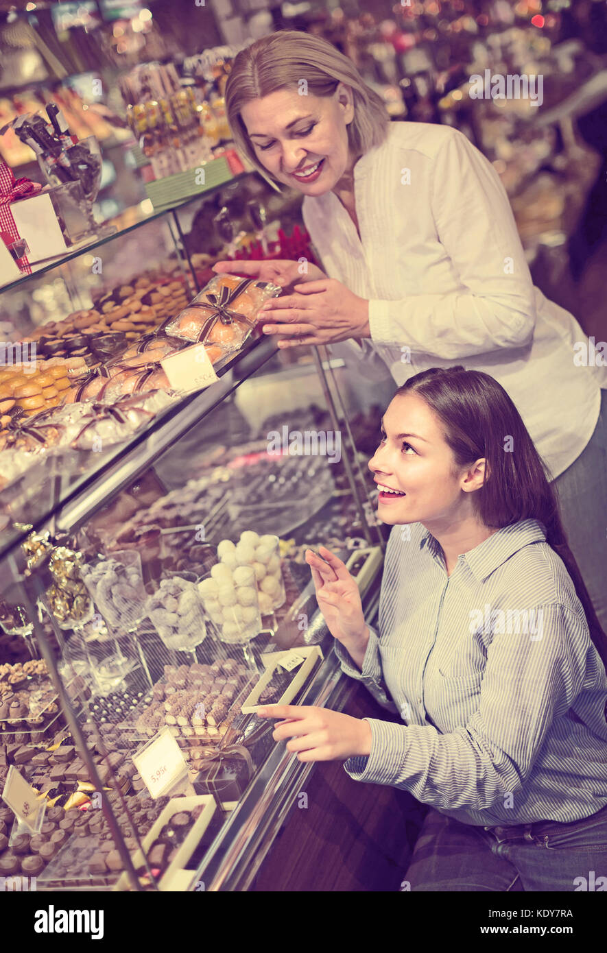 Happy women buying dark and white chocolate filled candies Stock Photo ...
