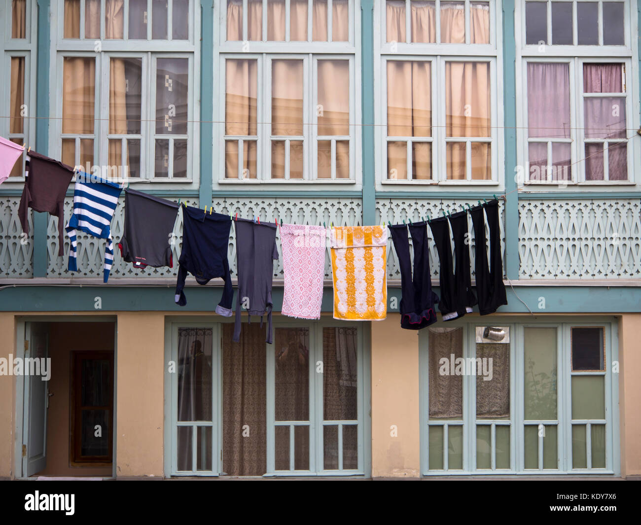 Washing line and building facade, house with glazed in balcony in ...