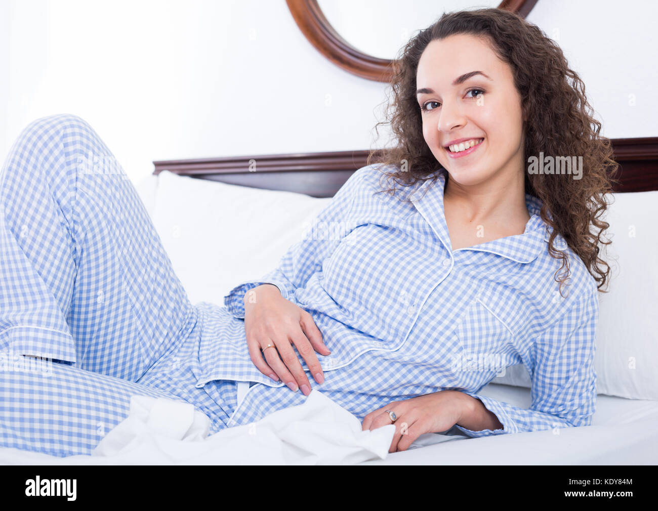 Brunette girl posing with blue pygamas in bed at home Stock Photo - Alamy