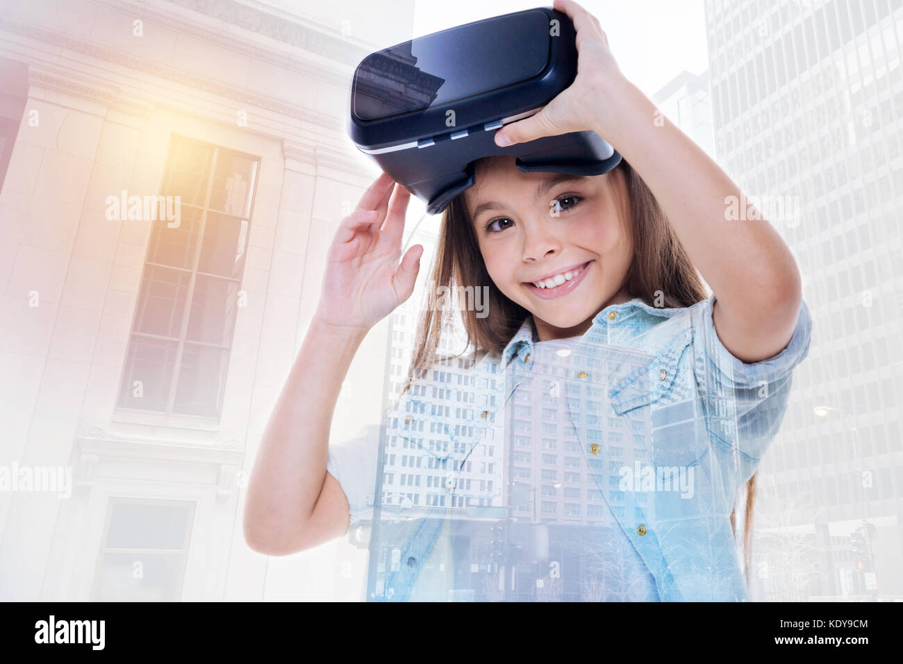 Cute little girl removing VR headset Stock Photo - Alamy