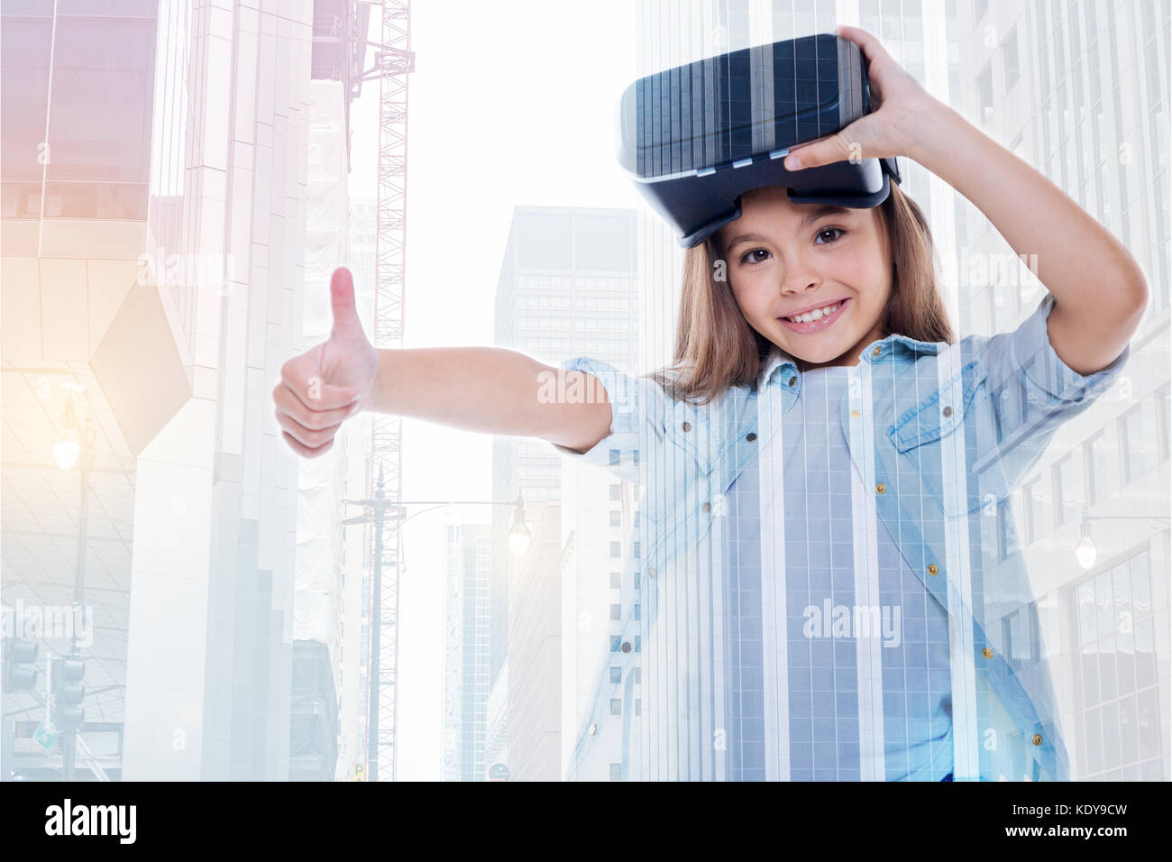 Smiling little girl removing VR headset and showing thumbs up Stock ...