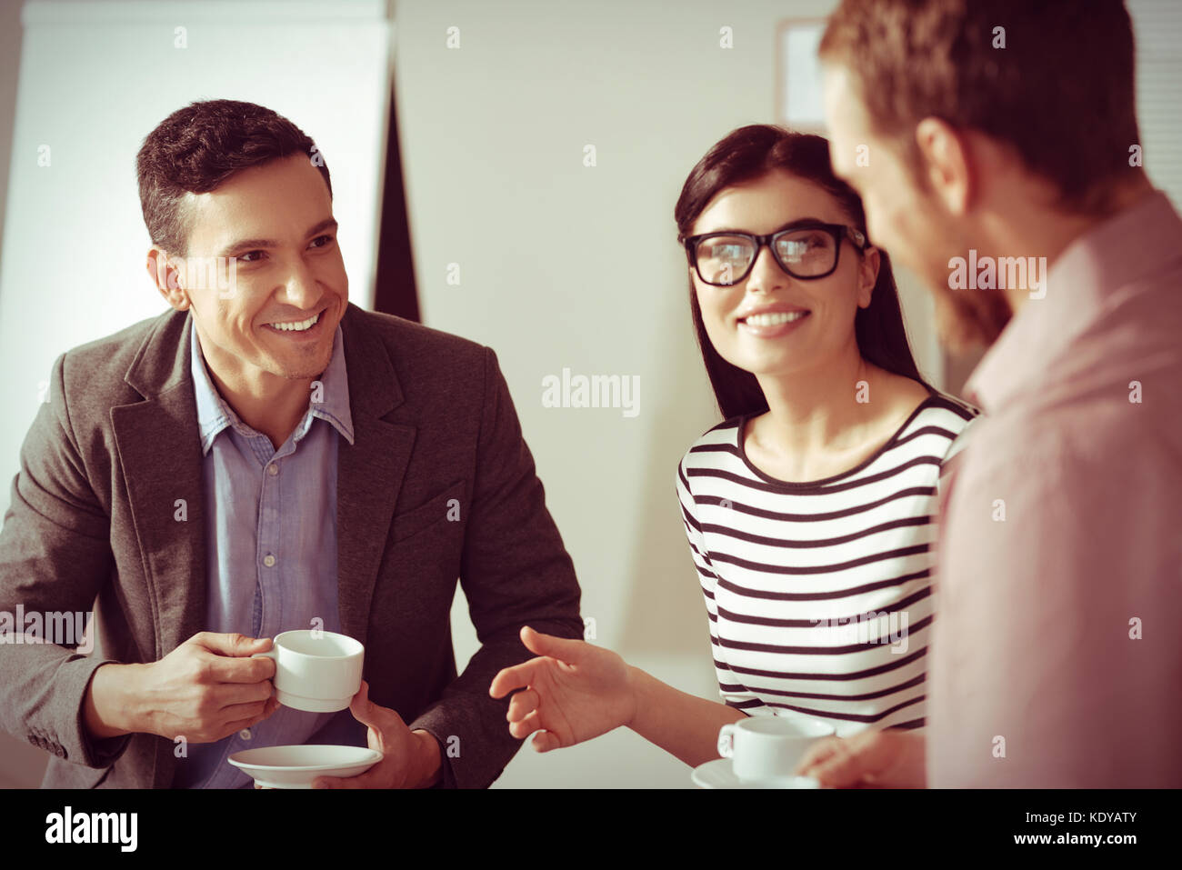 Joyful nice colleagues having coffee Stock Photo - Alamy