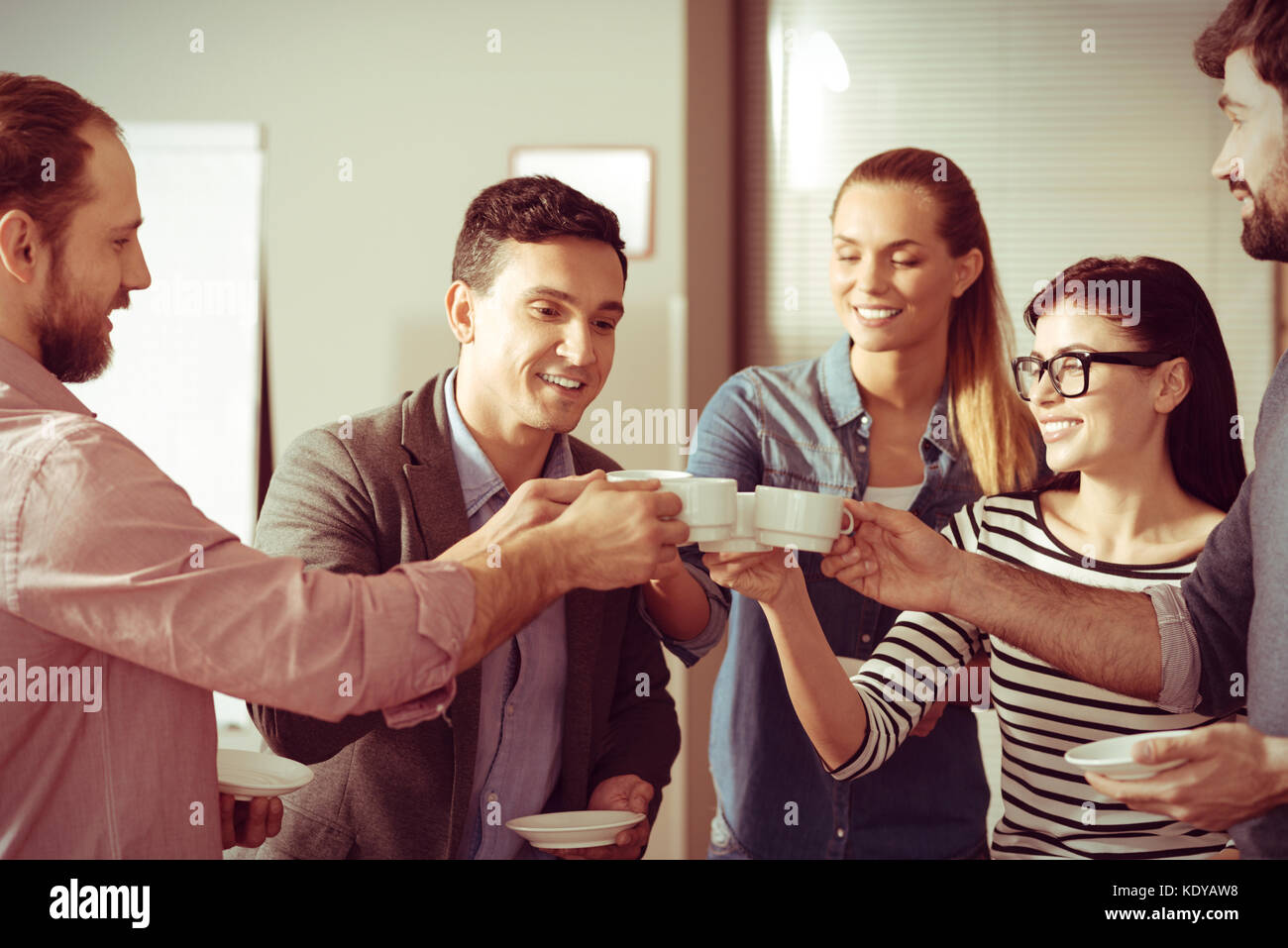 Happy delighted colleagues holding coffee cups Stock Photo - Alamy