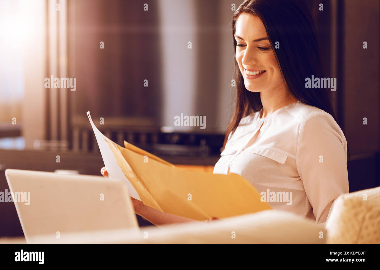 Smiling female checking important documents Stock Photo - Alamy