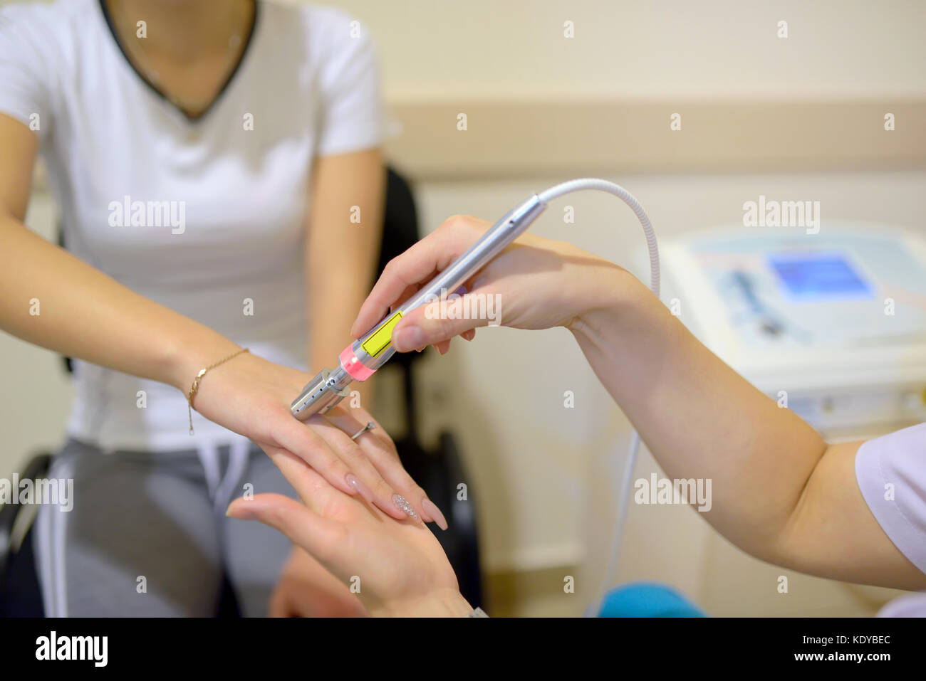 Young woman receiving laser therapy on wrist hand Stock Photo - Alamy