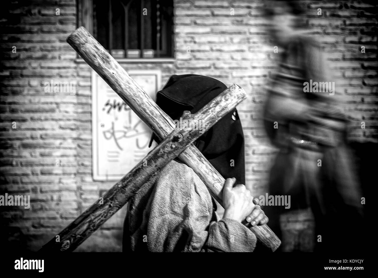 Penitent carrying wooden cross during station of penance in Holy Week ...