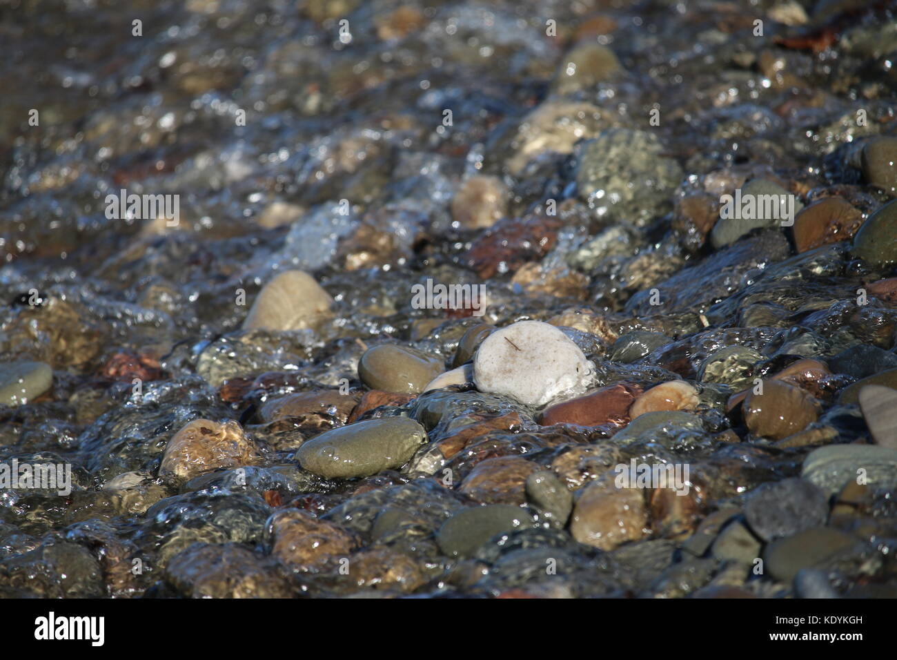 Water flowing over stones at the lake Stock Photo - Alamy