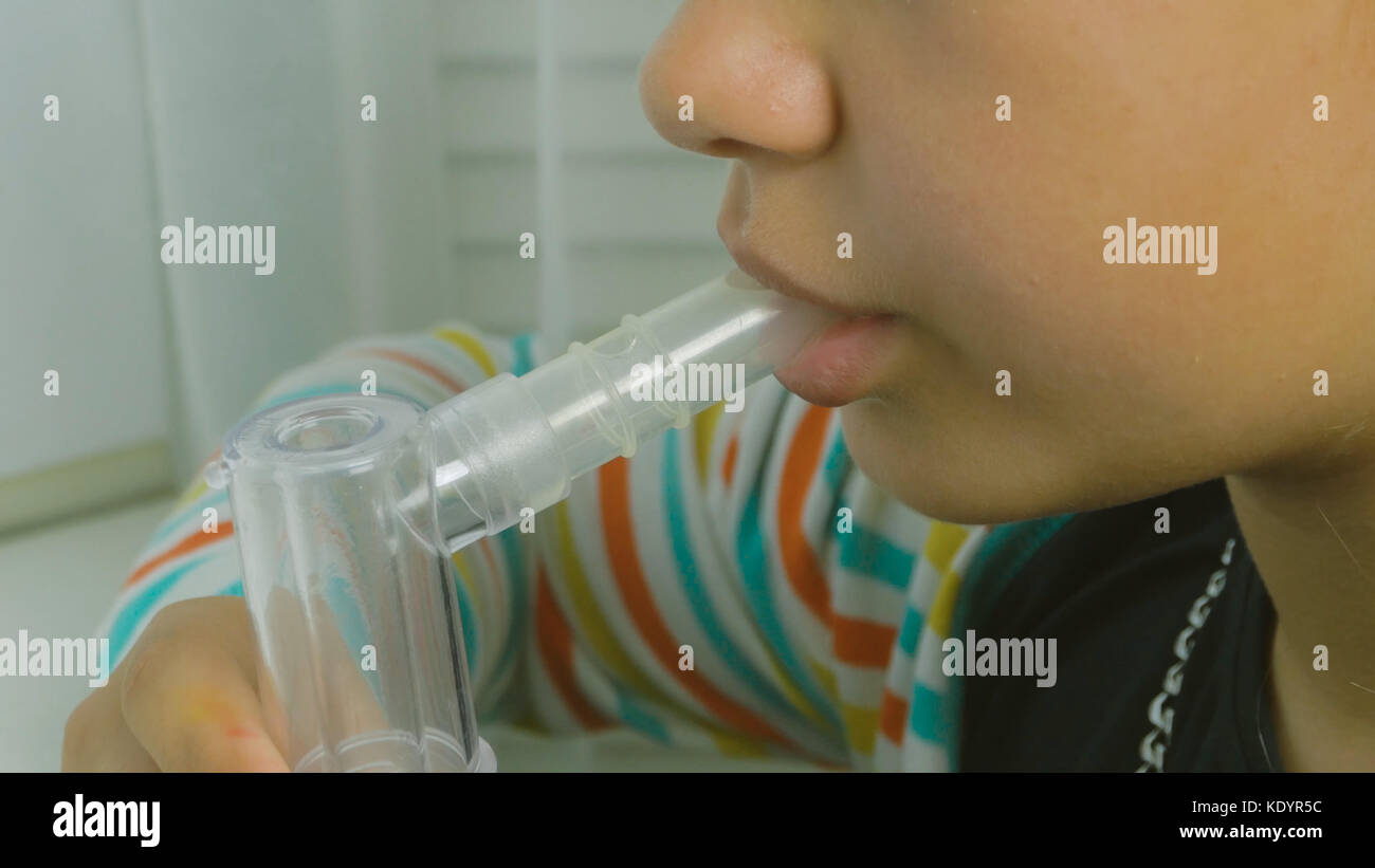 Girl breathing through a steam nebulizer. Treatment bronchopulmonary ...