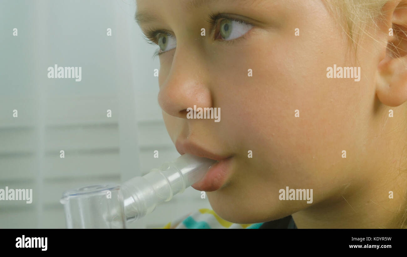 Girl breathing through a steam nebulizer. Treatment bronchopulmonary ...