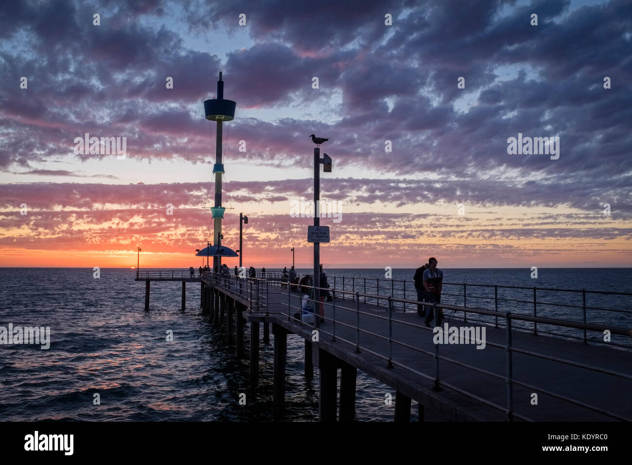 People enjoy a gorgeous sunset at the seaside on Adelaide's Brighton ...