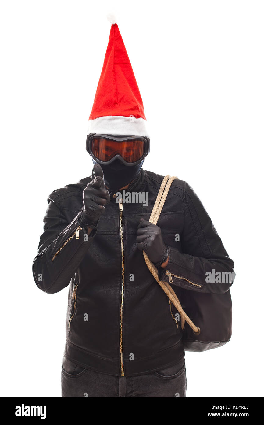Masked burglar with santa claus cap holding his sack, posing on ...