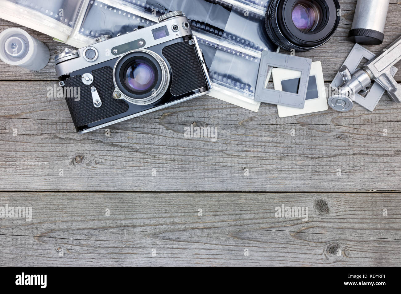 negative films, lenses and retro camera on wooden table background with ...