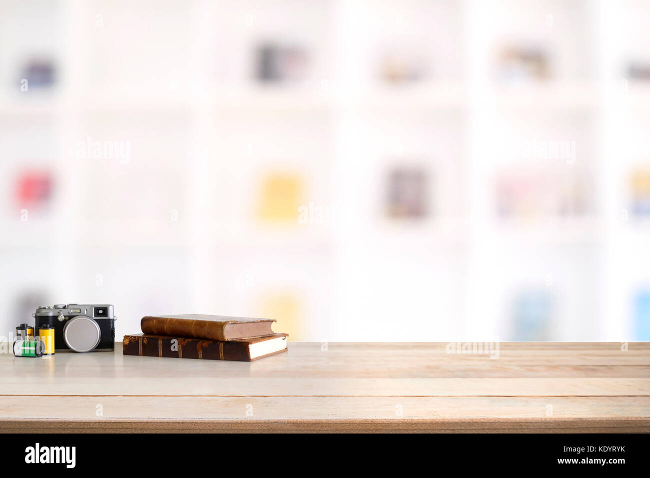 Retro book and retro camera on wood shelf in library with copy space ...
