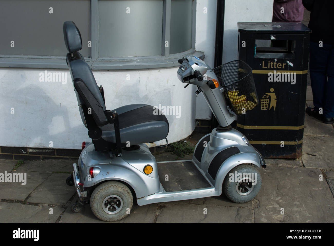 Invalid scooter and litter bin UK Stock Photo - Alamy