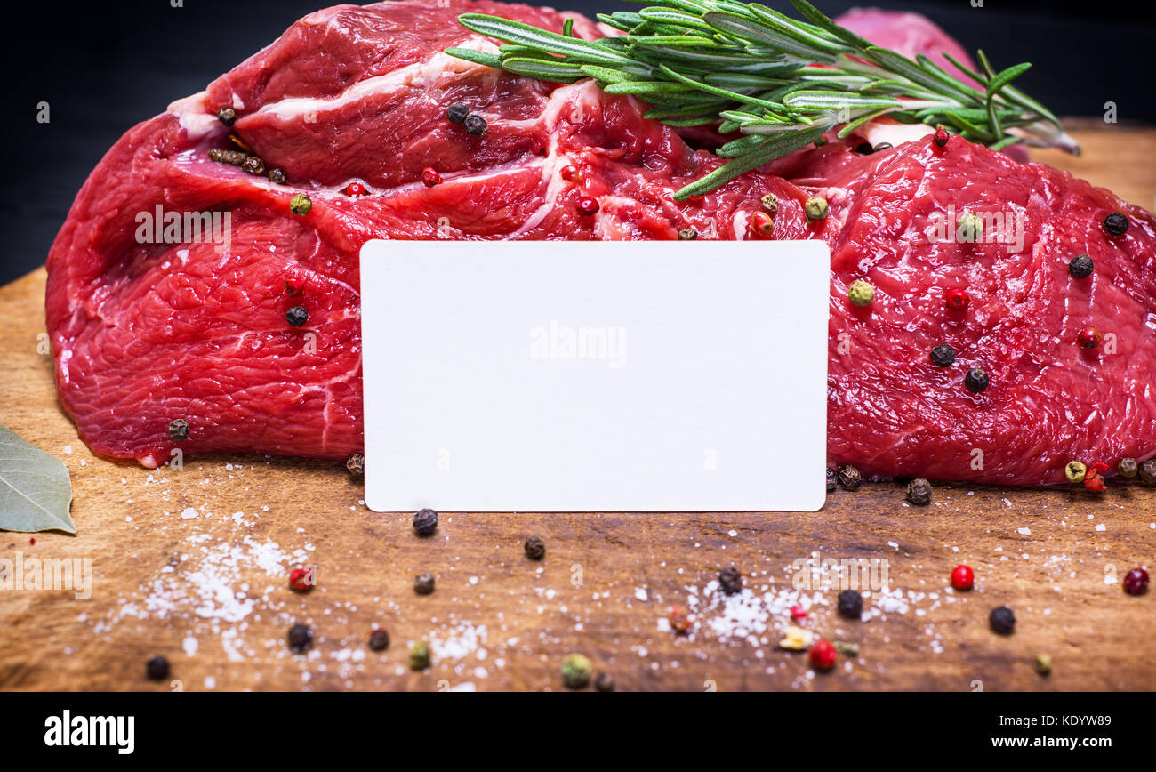 raw fresh piece of beef meat and an empty white paper tag on a brown ...