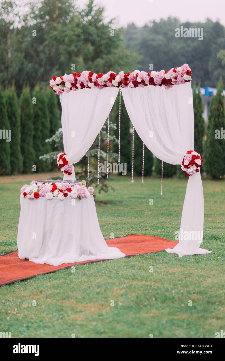 The wedding composition of the wedding arch and table decorated with ...