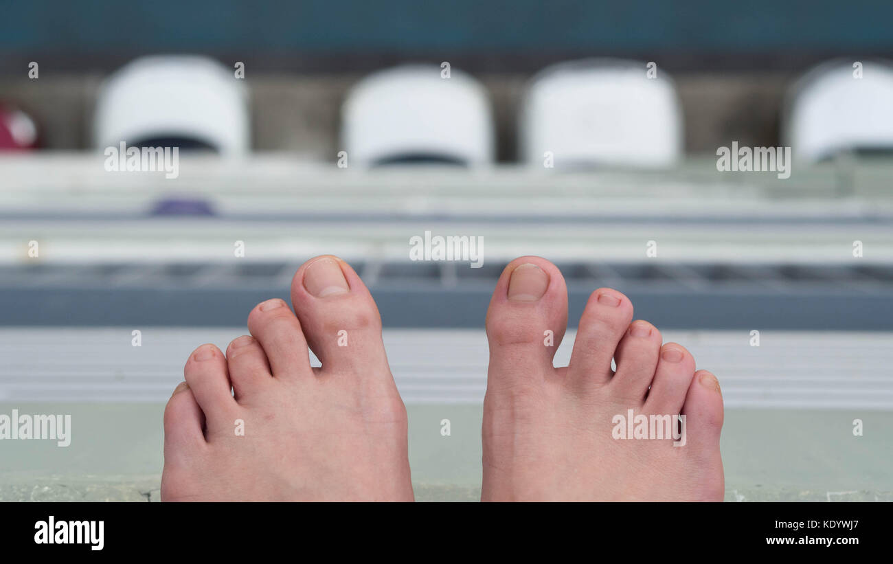 Feet hanging by the edge of a building Stock Photo - Alamy