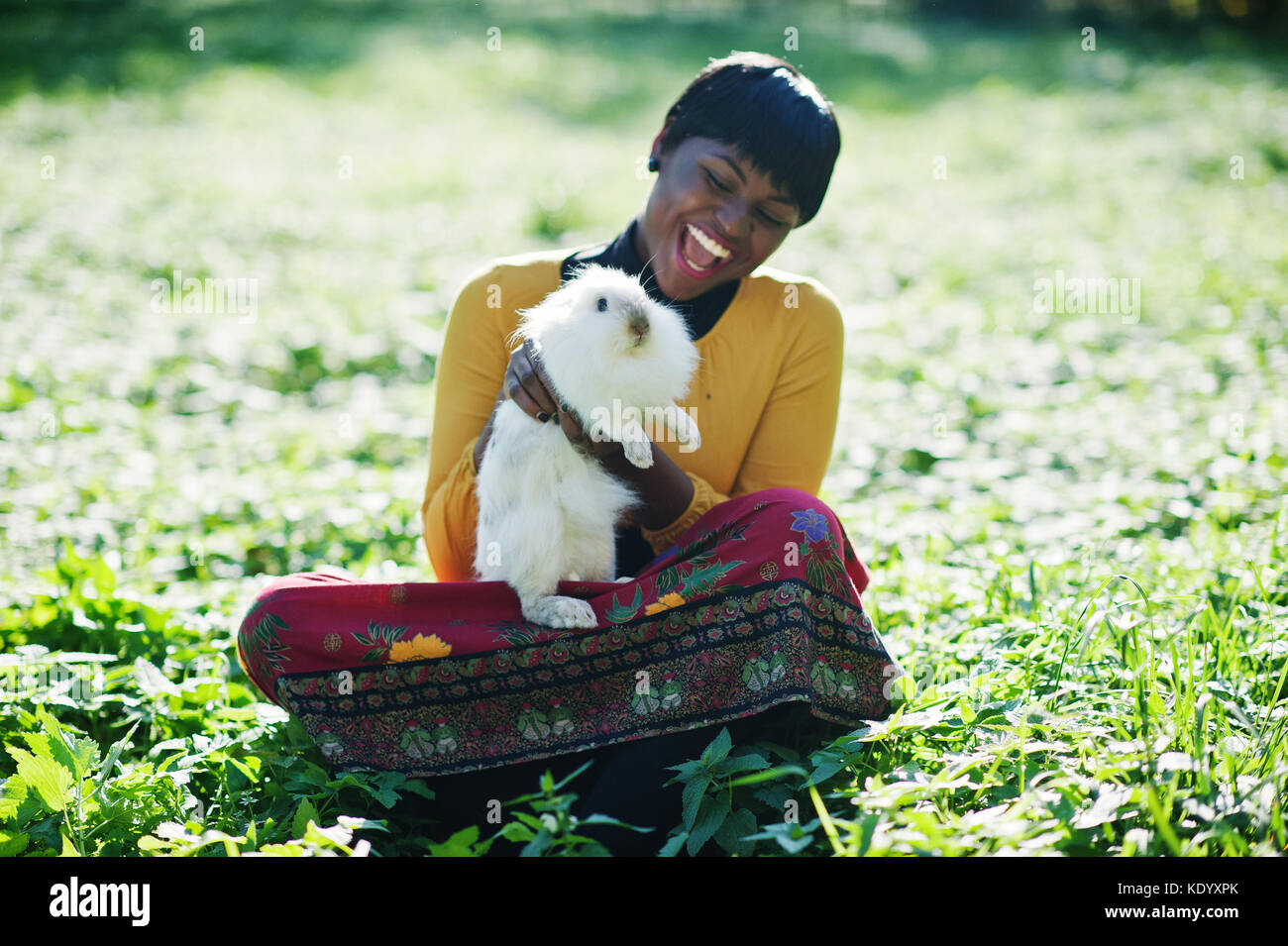 African american girl at yellow and red dress with white rabbit at ...