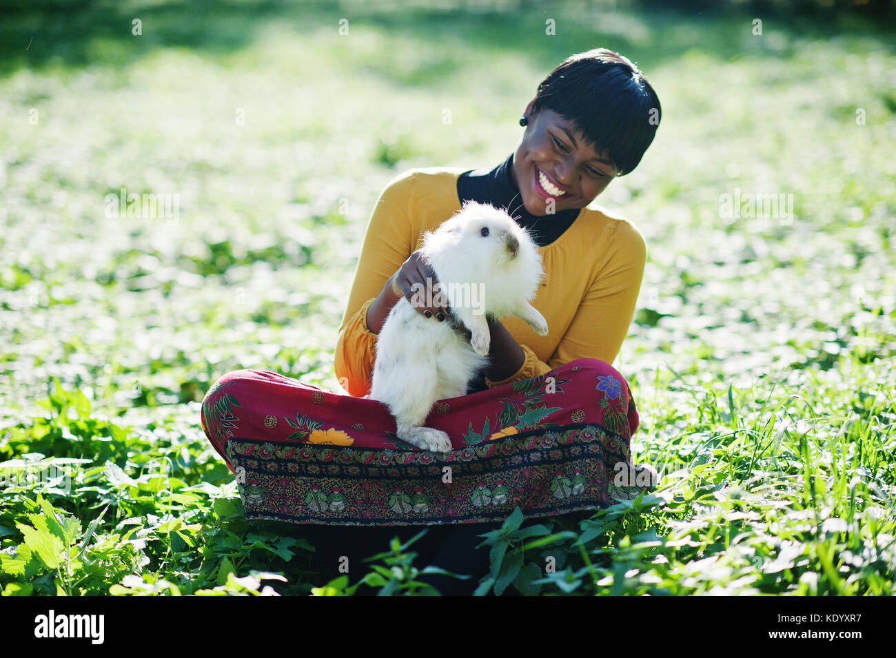 African american girl at yellow and red dress with white rabbit at ...