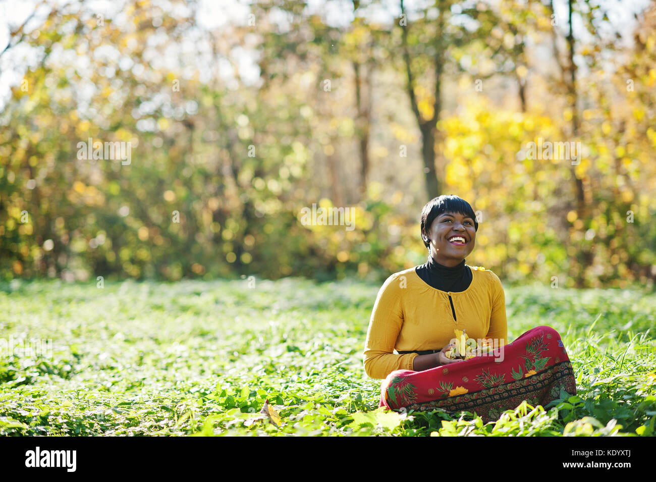 African american girl at yellow and red dress at autumn fall park Stock ...