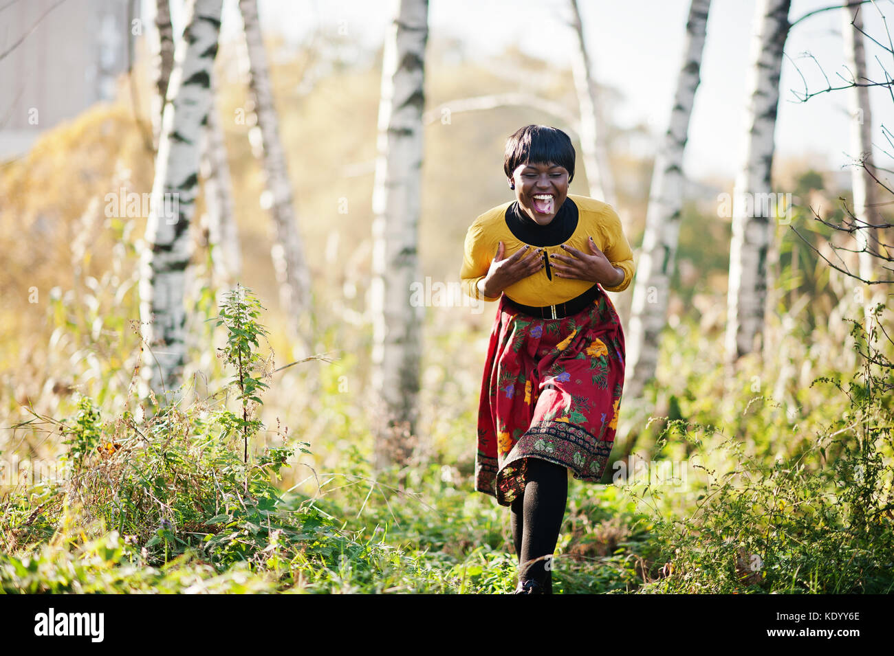 African american girl at yellow and red dress at golden autumn fall ...