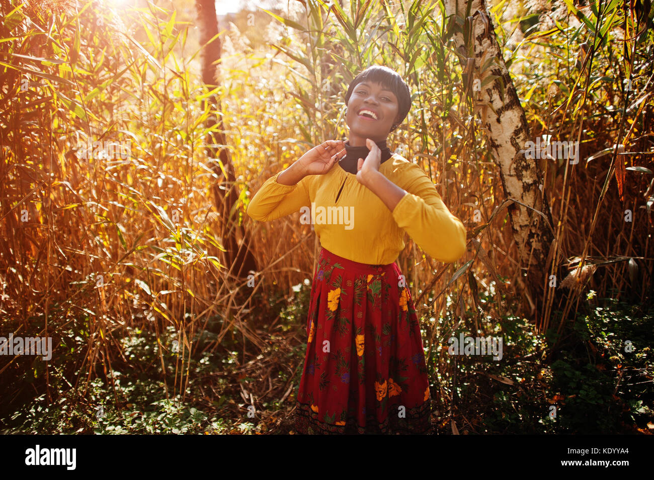 African american girl at yellow and red dress at golden autumn fall ...