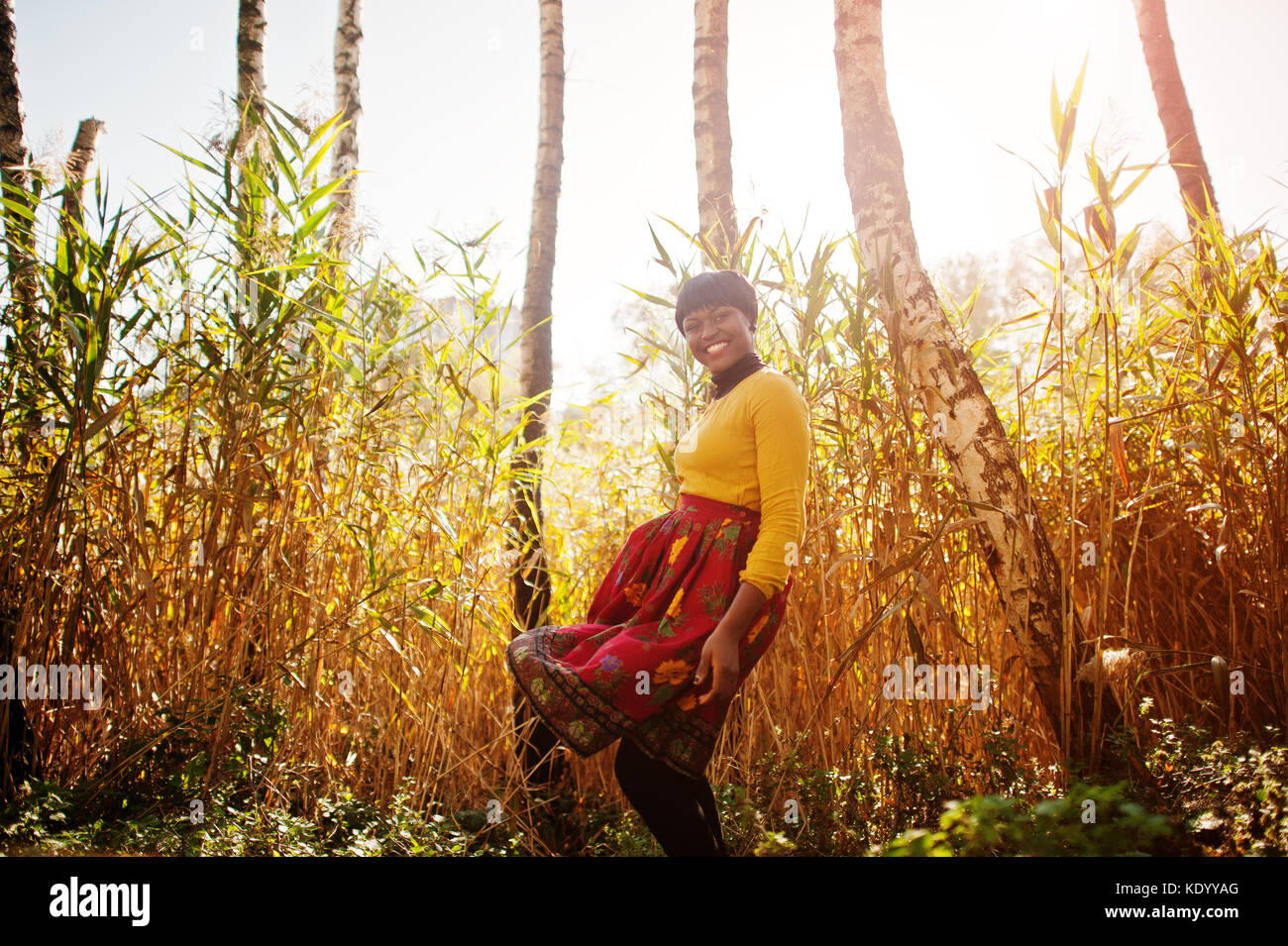 African american girl at yellow and red dress at golden autumn fall ...