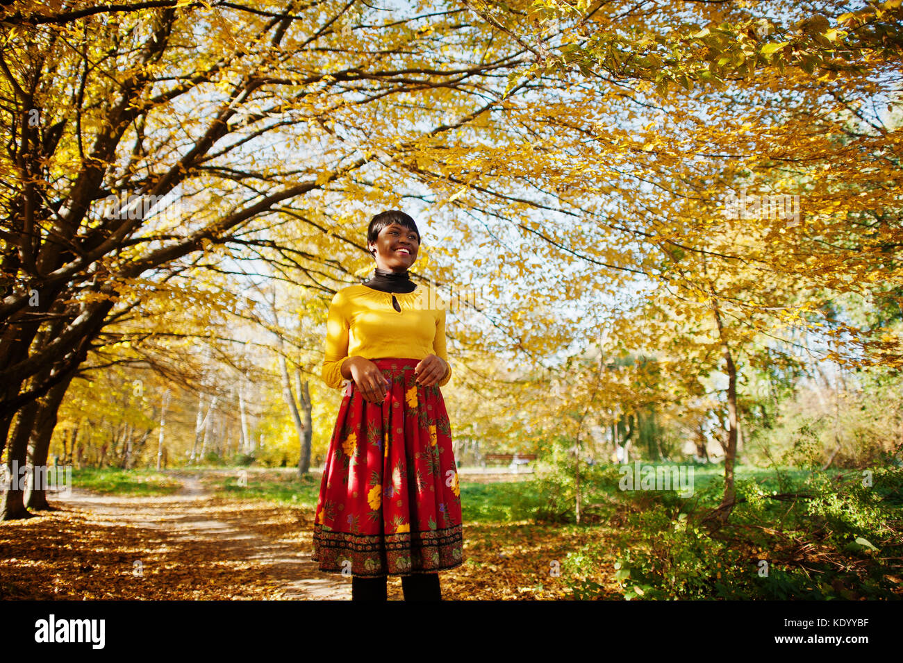 African american girl at yellow and red dress at golden autumn fall ...