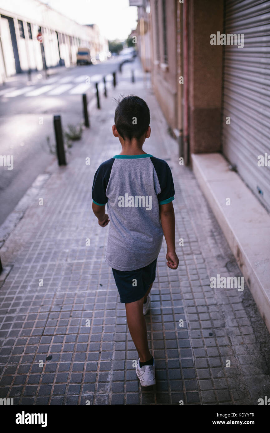 Boy walking on the street Stock Photo - Alamy