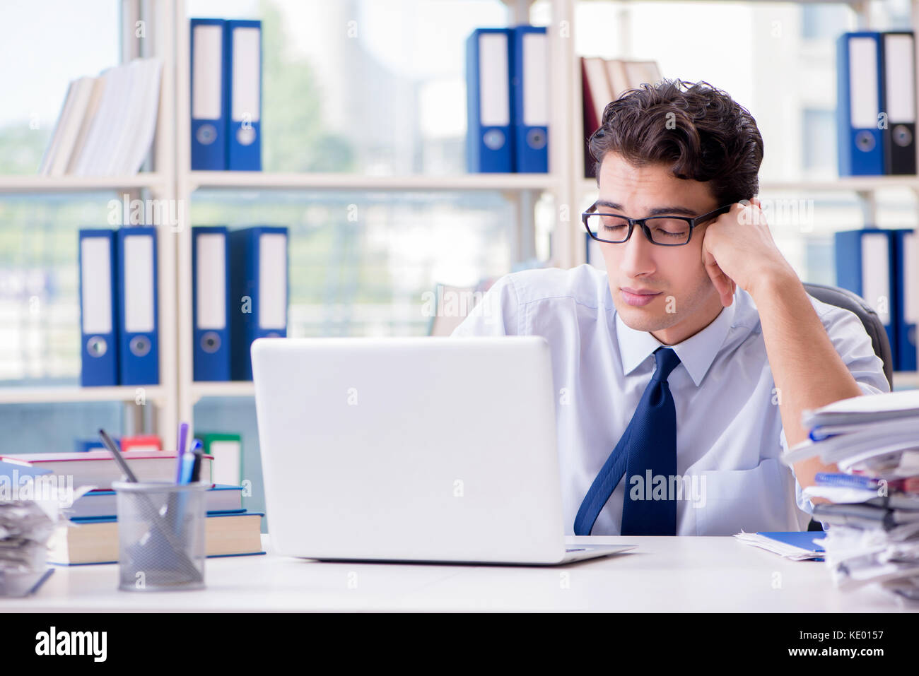 Tired exhausted businessman sitting in the office Stock Photo - Alamy