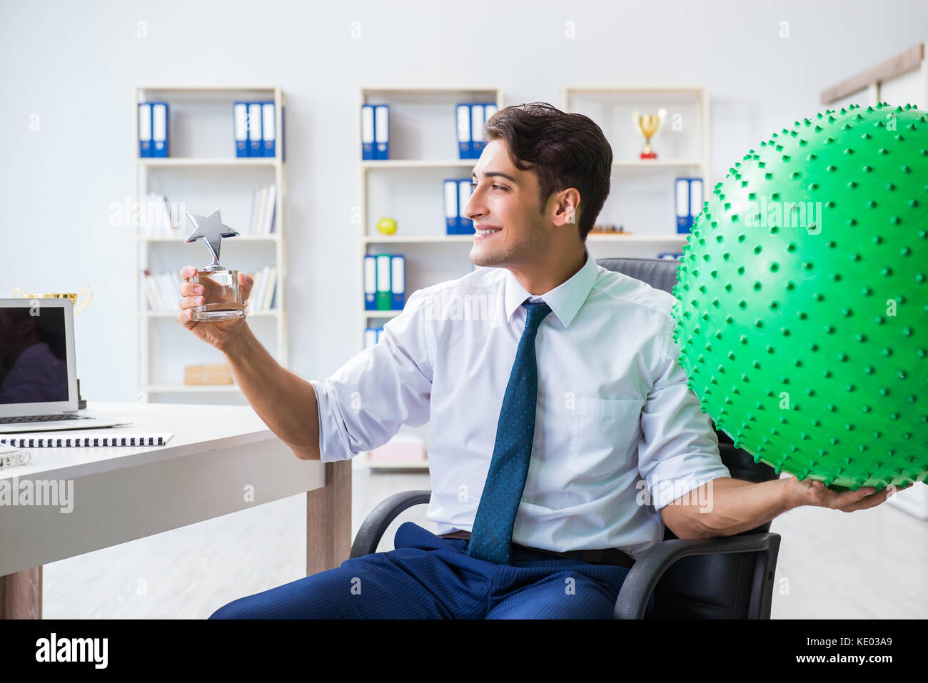 Young businessman doing sports stretching at workplace Stock Photo - Alamy