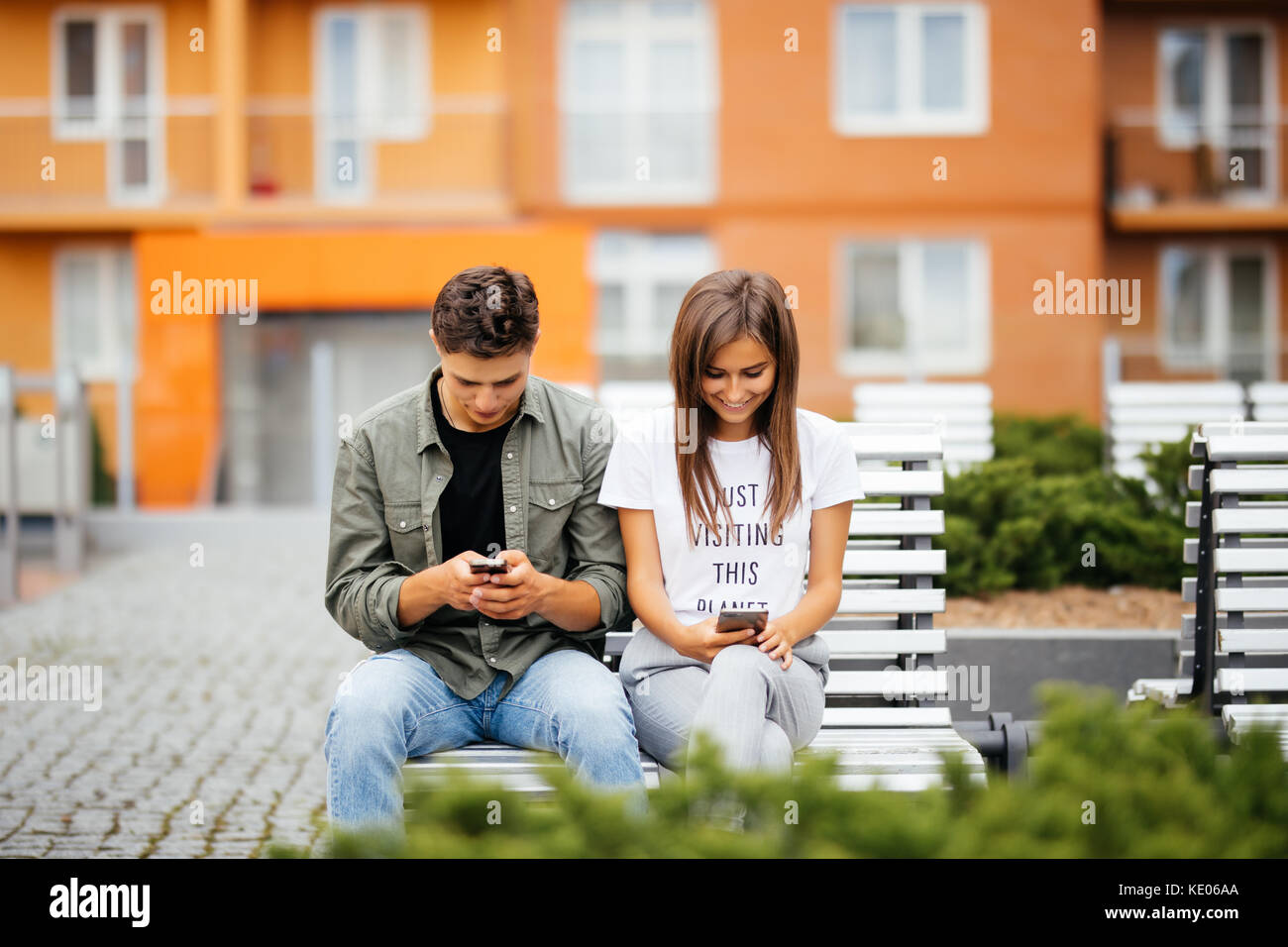 Mobile phone addiction concept - couple looking at their mobile phone ...