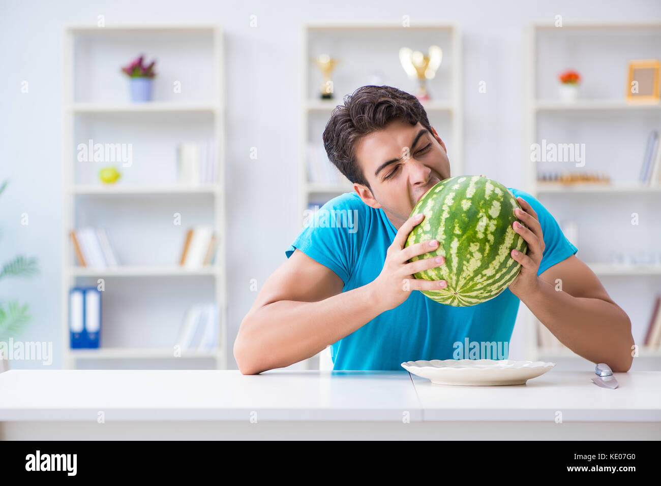Man eating watermelon at home Stock Photo - Alamy