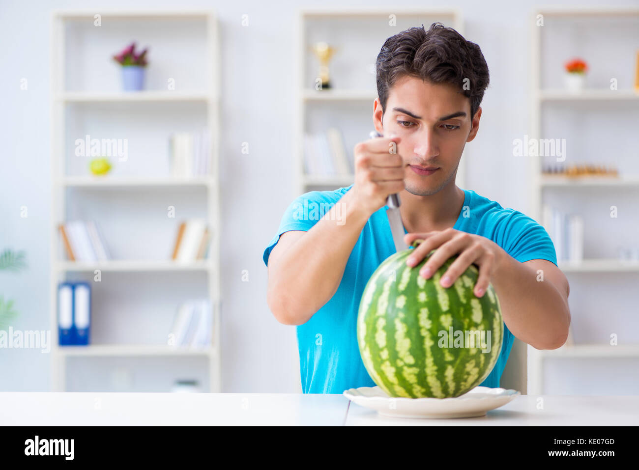 Man eating watermelon at home Stock Photo - Alamy