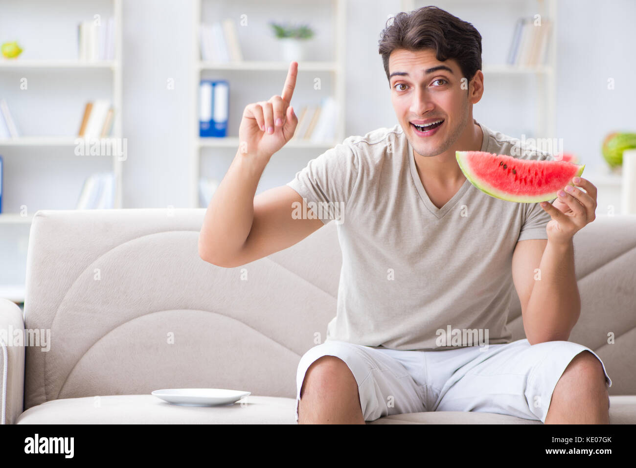Man eating watermelon at home Stock Photo - Alamy