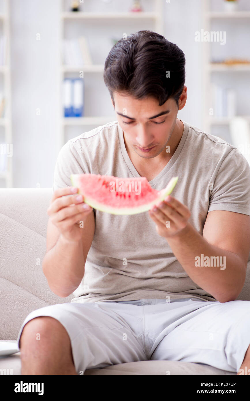 Man eating watermelon at home Stock Photo - Alamy