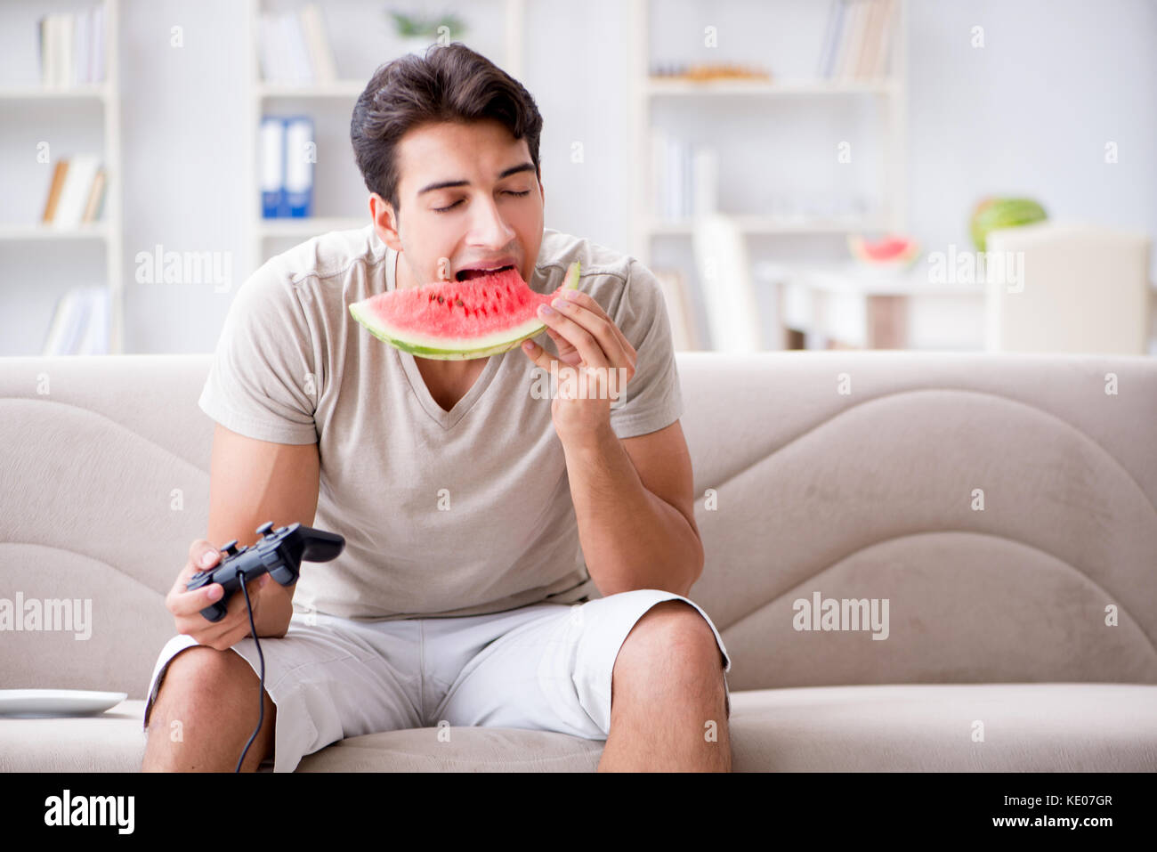 Man eating watermelon at home Stock Photo - Alamy
