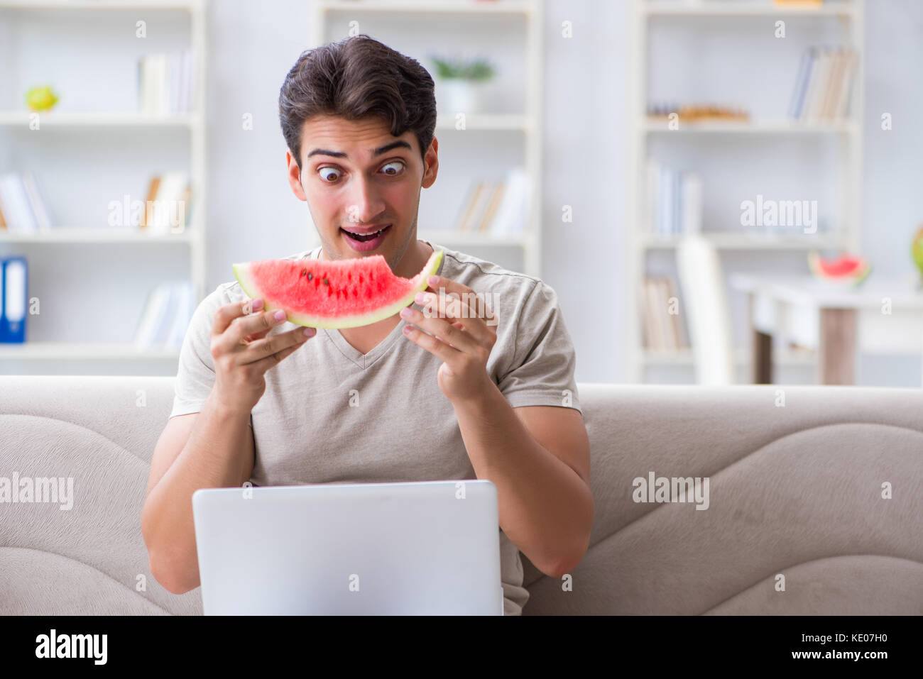 Man eating watermelon at home Stock Photo - Alamy