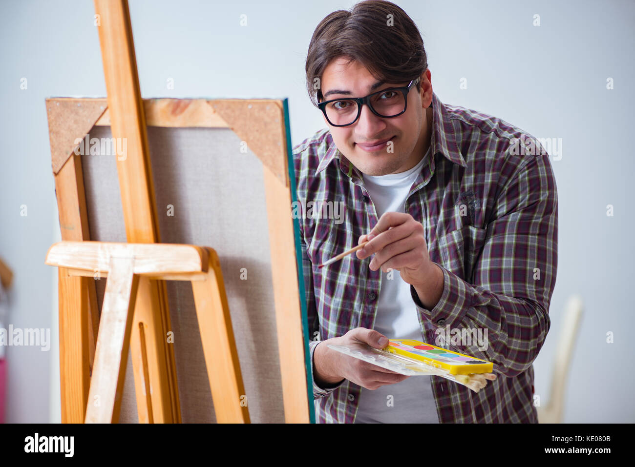 Young male artist drawing pictures in bright studio Stock Photo - Alamy