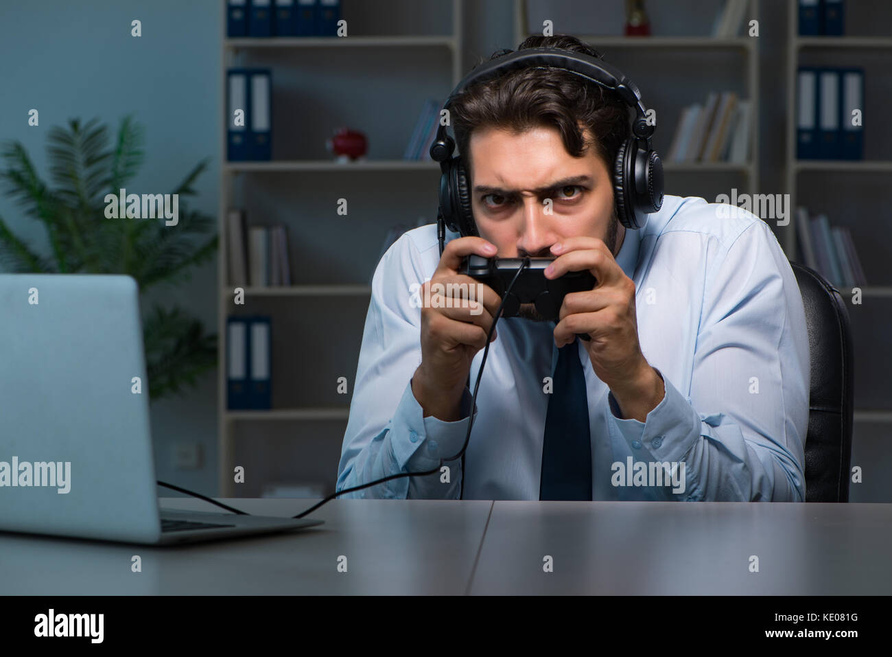 Businessman gamer staying late to play games Stock Photo - Alamy