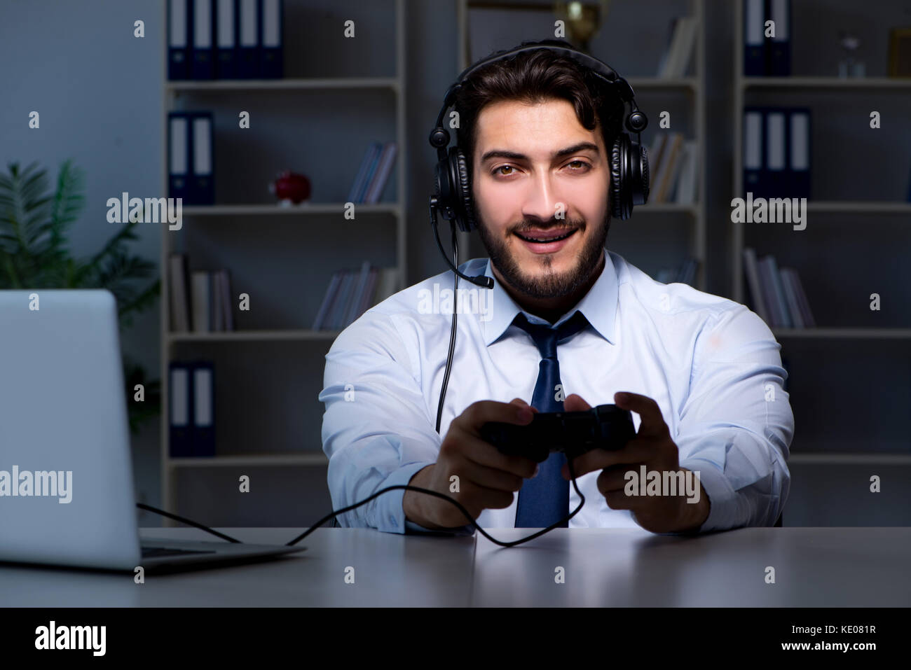 Businessman gamer staying late to play games Stock Photo - Alamy