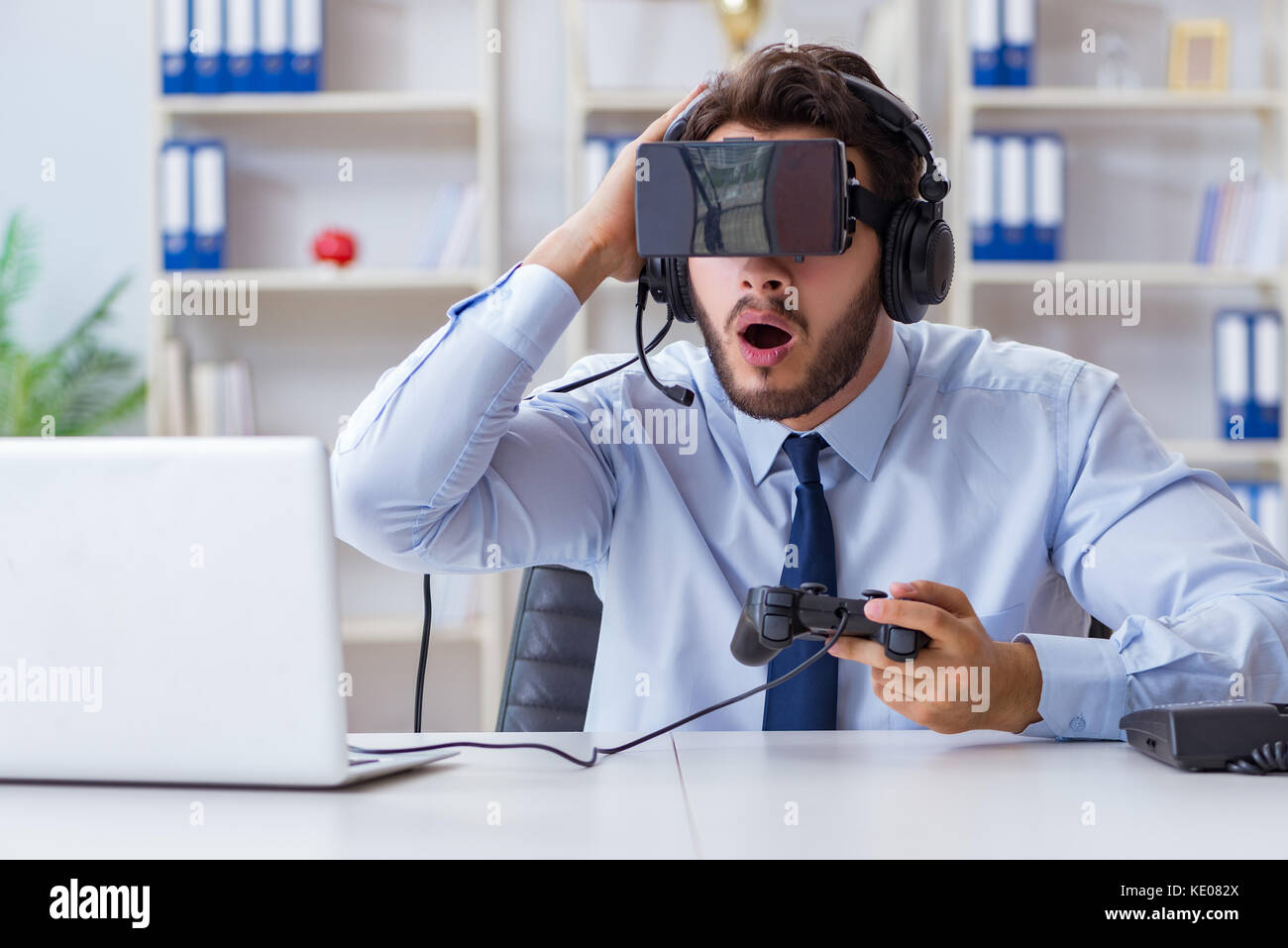Businessman gamer in office playing games Stock Photo - Alamy