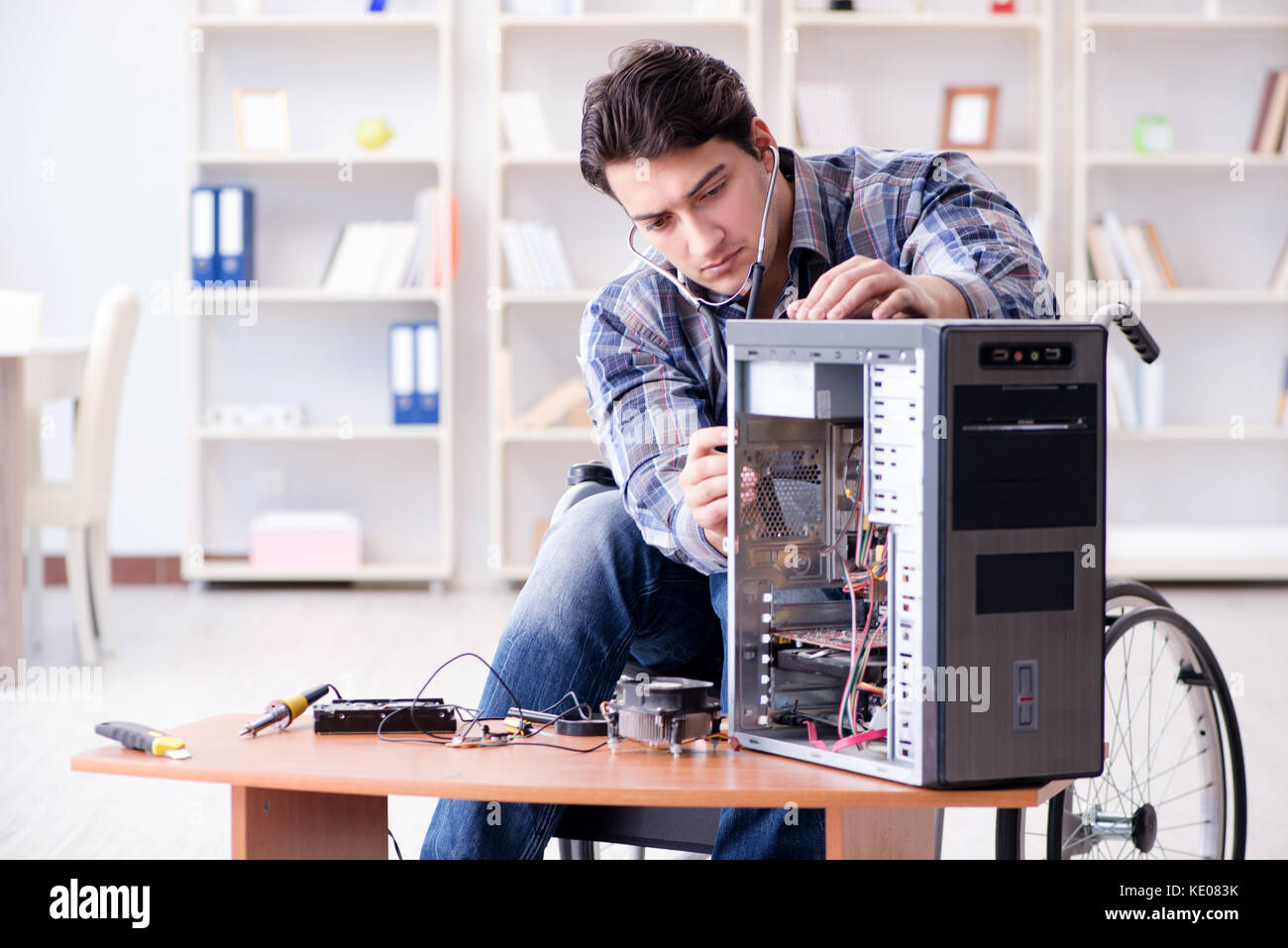 Disabled man on wheelchair repairing computer Stock Photo - Alamy