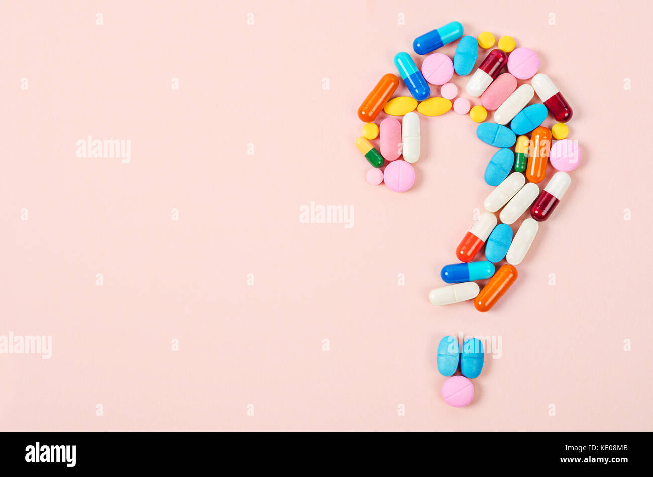 Question mark made of lots of pills and capsules on color background ...