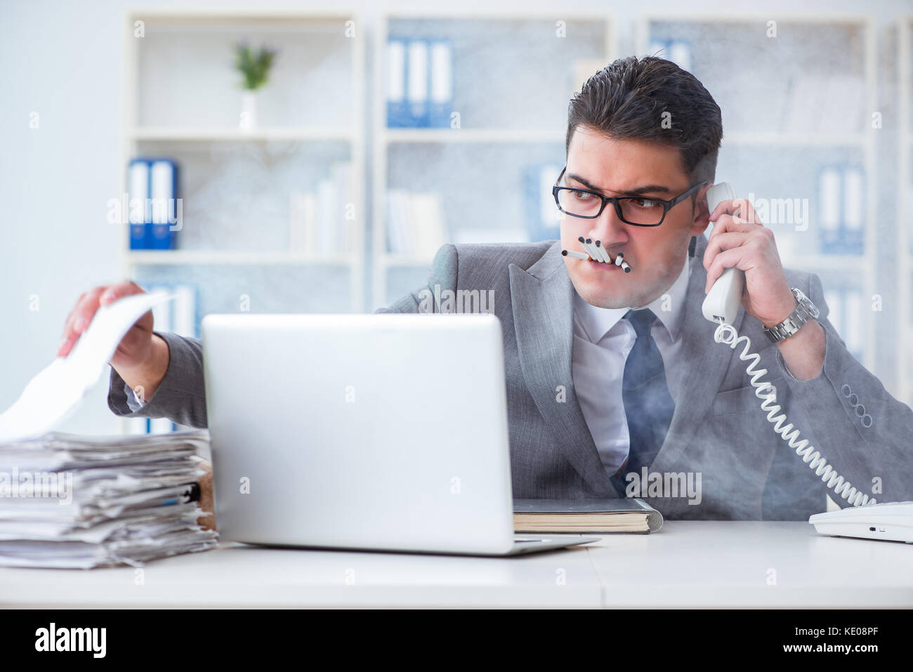 Businessman smoking in office at work Stock Photo - Alamy