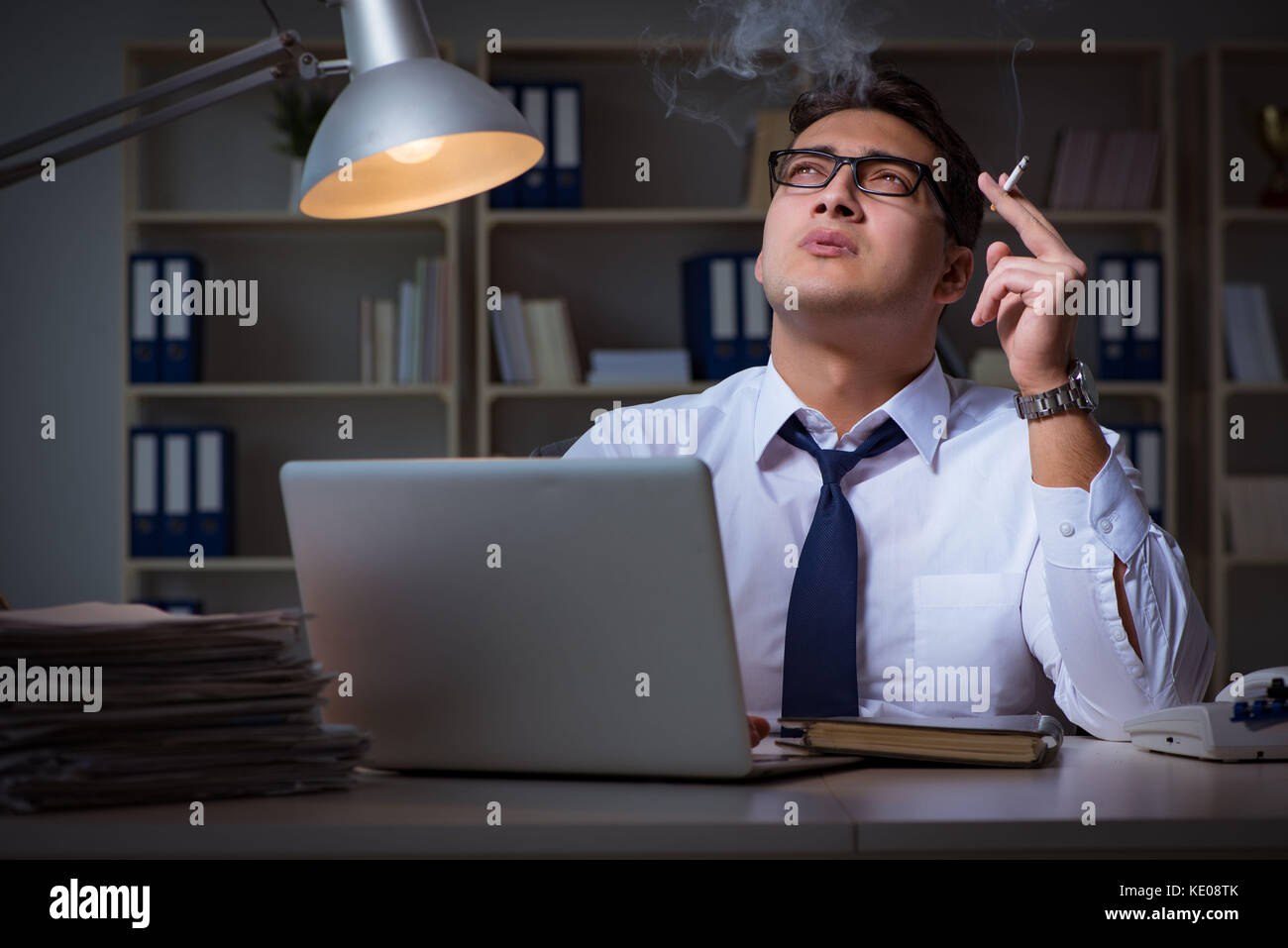 Businessman under stress smoking in office Stock Photo - Alamy