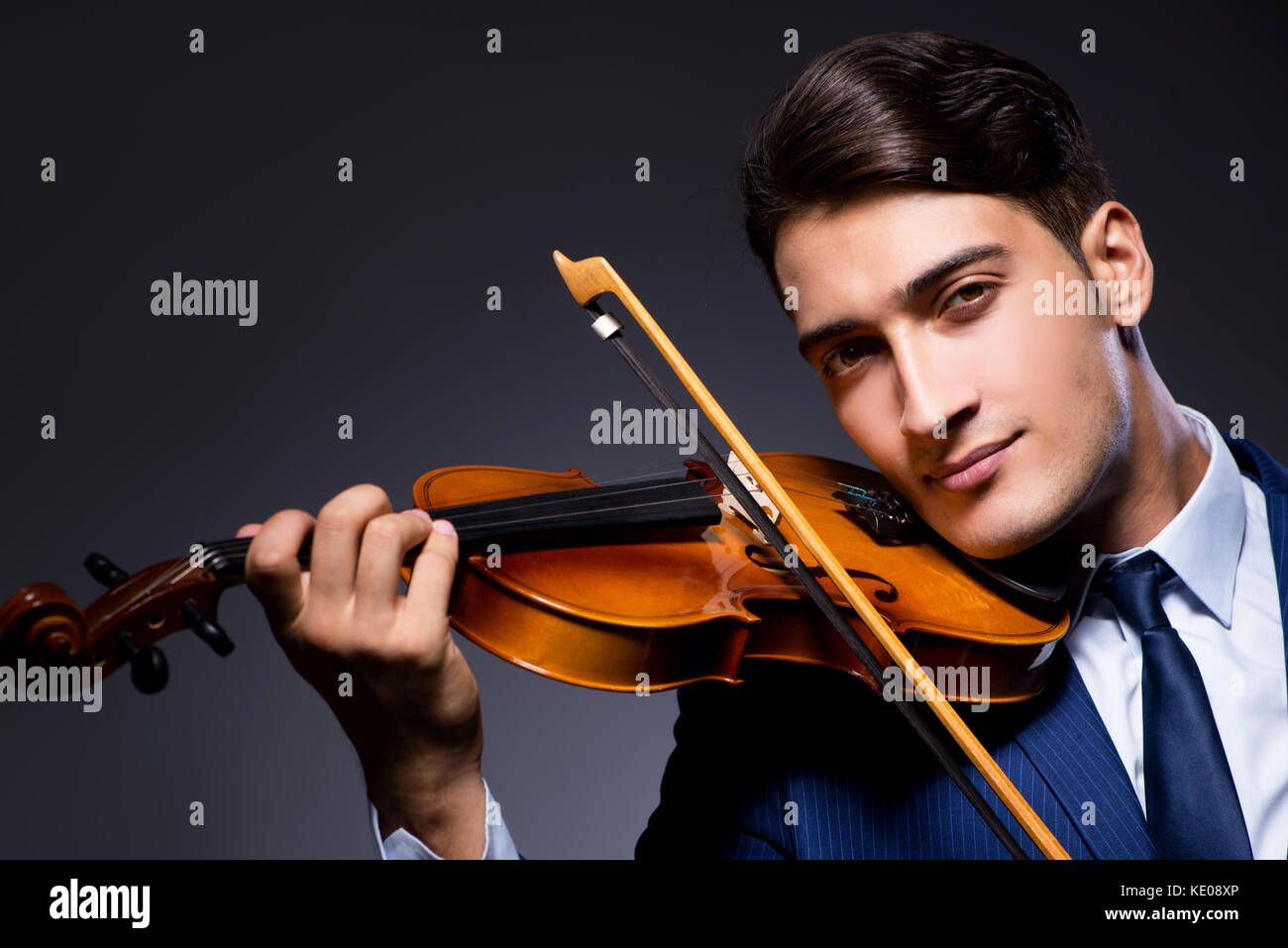 Young man playing violin in dark room Stock Photo - Alamy