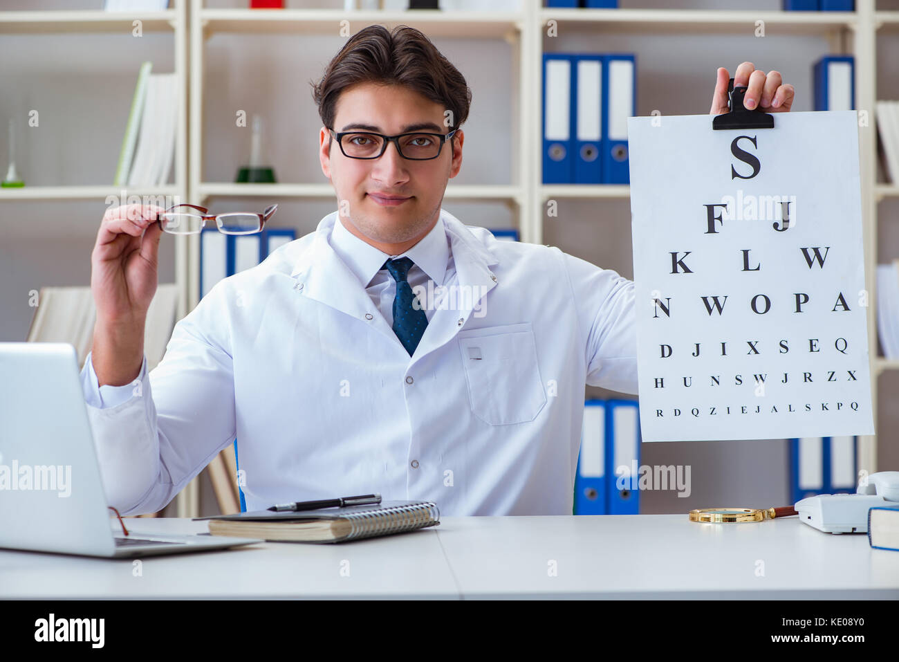Doctor optician with letter chart conducting an eye test check Stock ...