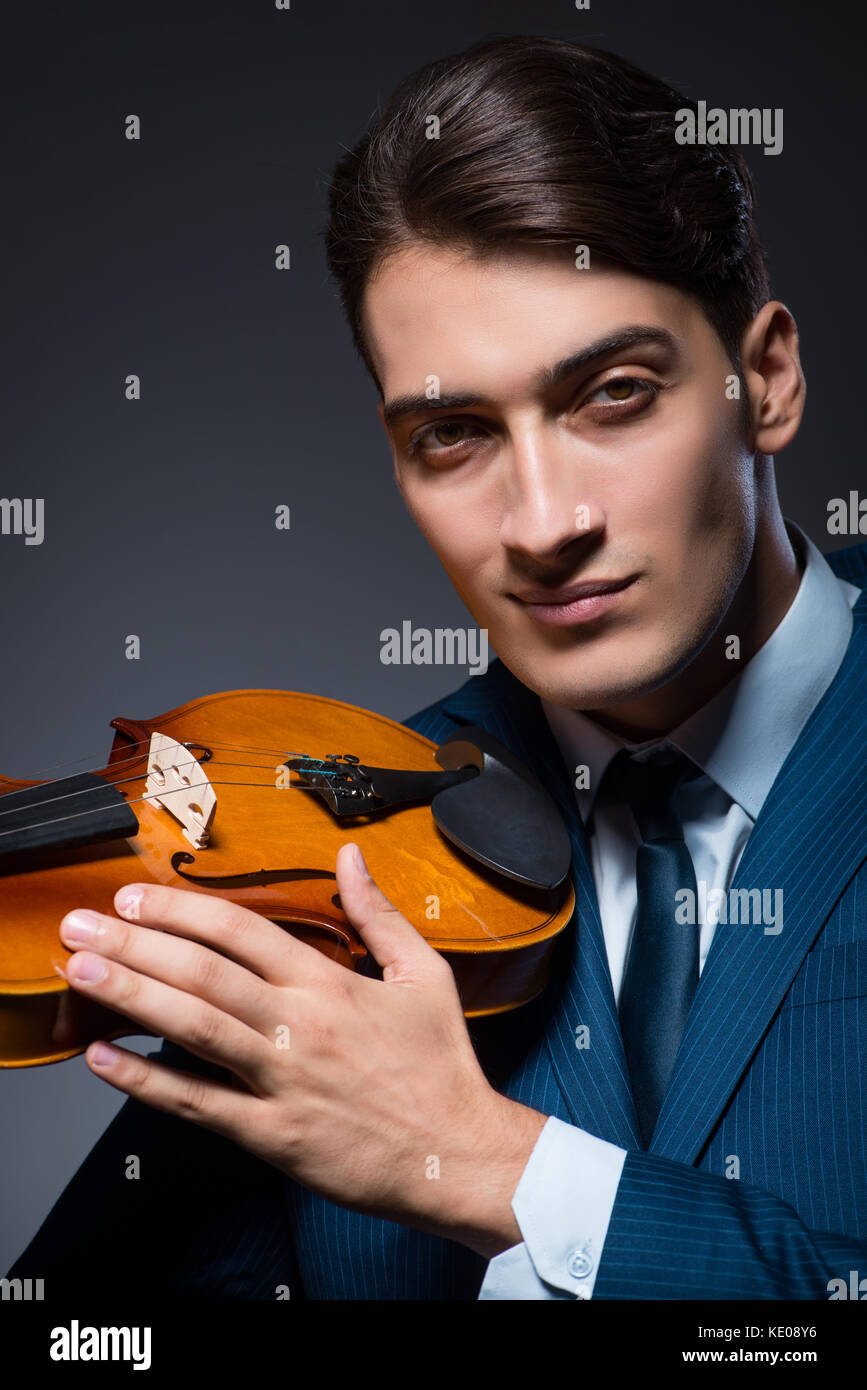 Young man playing violin in dark room Stock Photo - Alamy