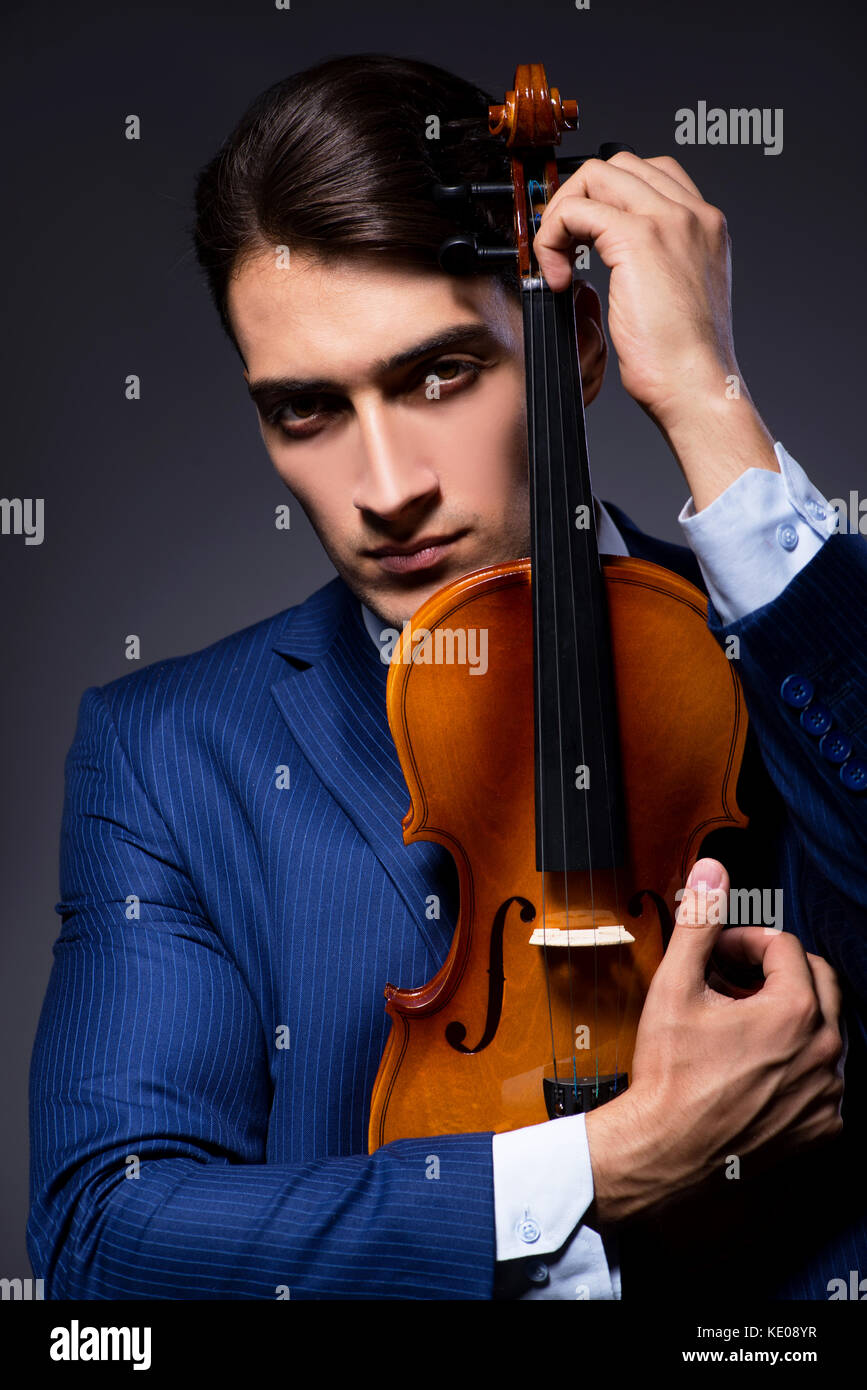 Young man playing violin in dark room Stock Photo - Alamy